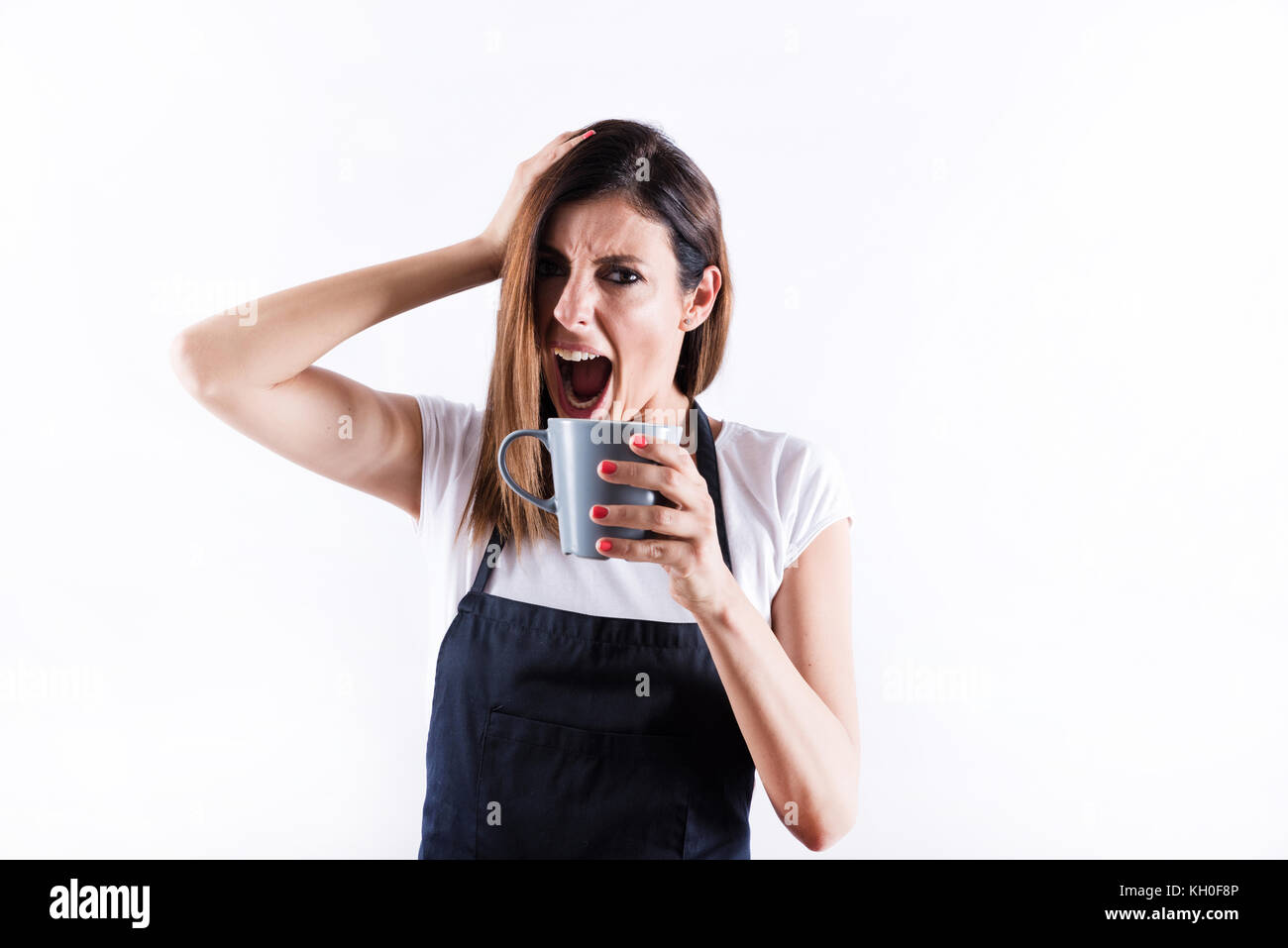 A beautiful young barista woman holding a cup of coffee and screaming ...