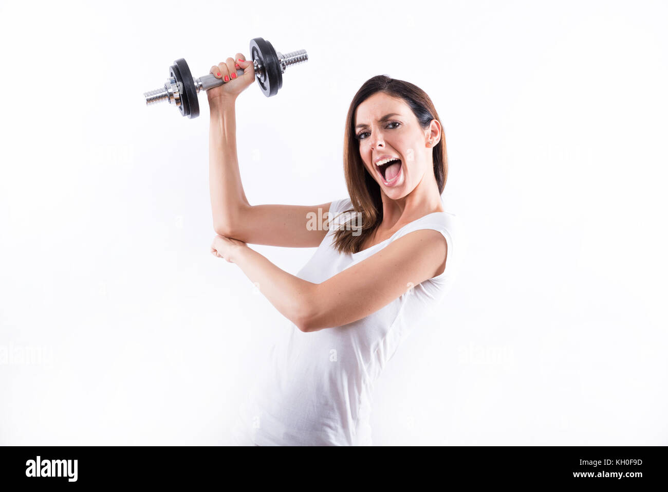A beautiful young woman lifting weight and screaming Stock Photo - Alamy