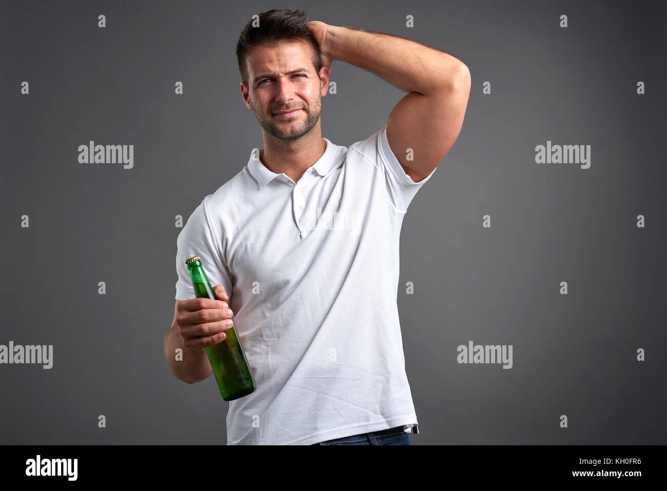 A handsome young man feeling desperate and grabbing his head while ...