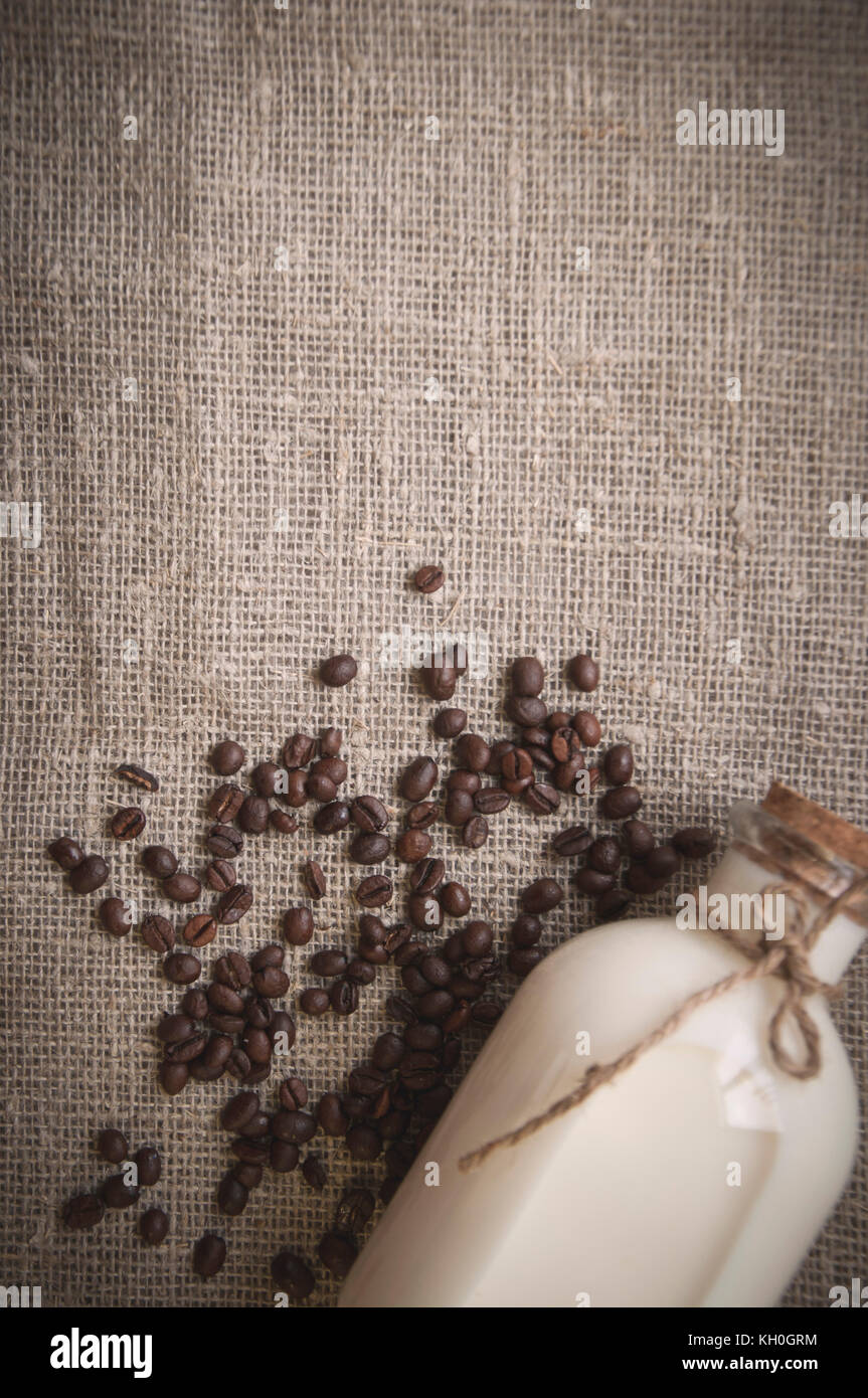 bottle of milk and loose coffee beans on background of linen Stock ...