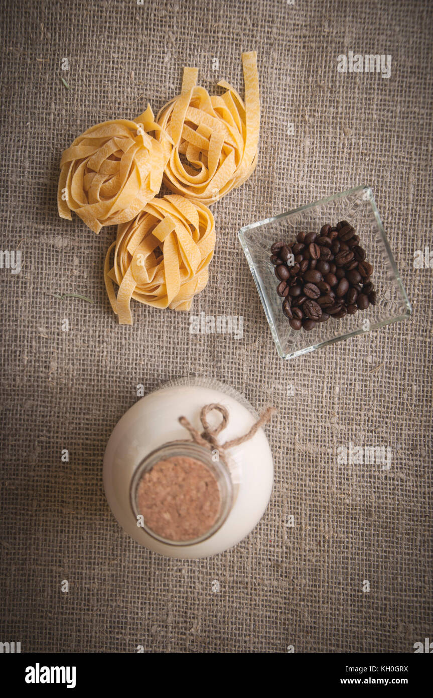 bottle of milk, raw fettuccine pasta and coffee beans Stock Photo - Alamy