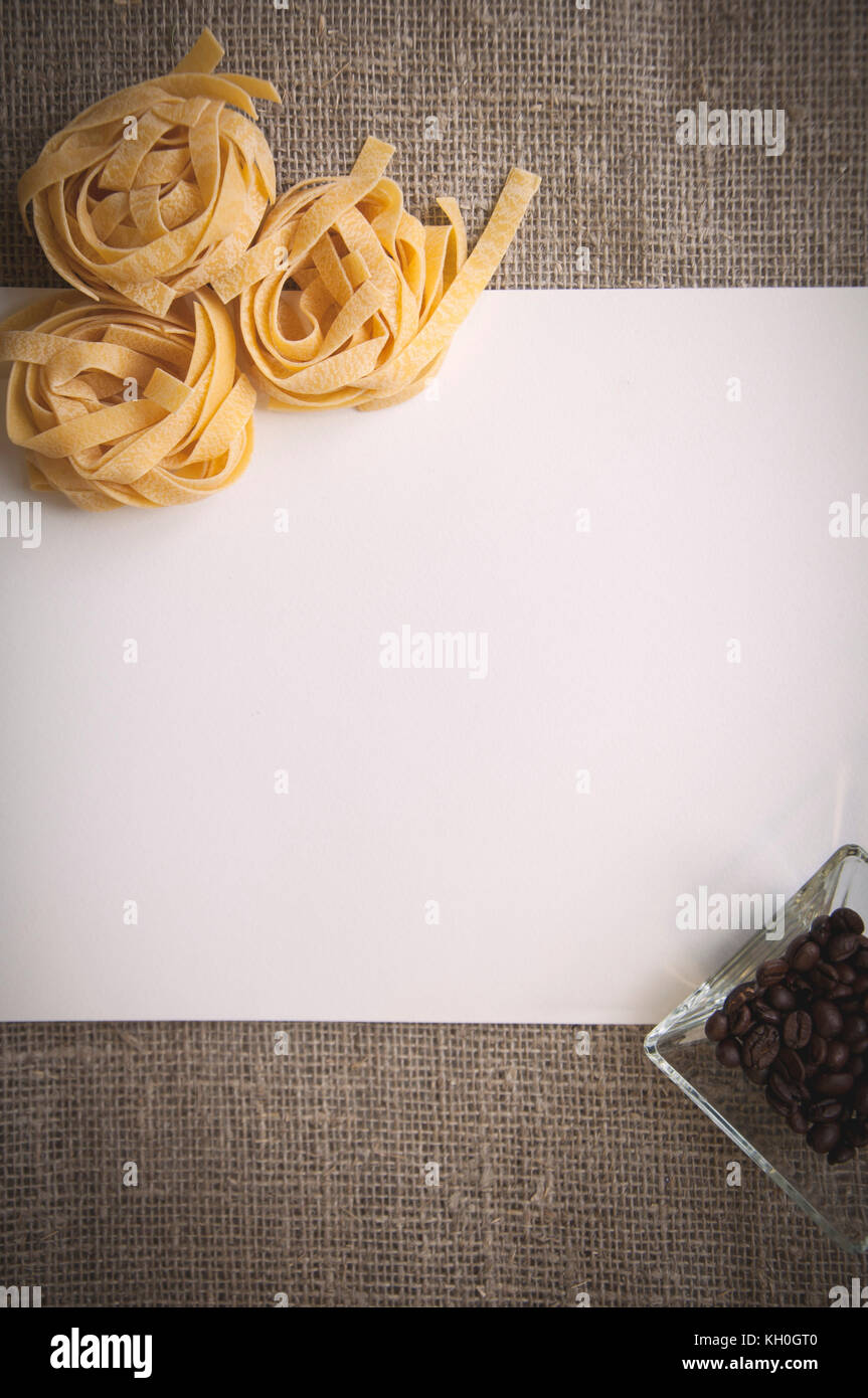 Raw fettuccine pasta and coffee beans in bowl on linen fabric Stock ...