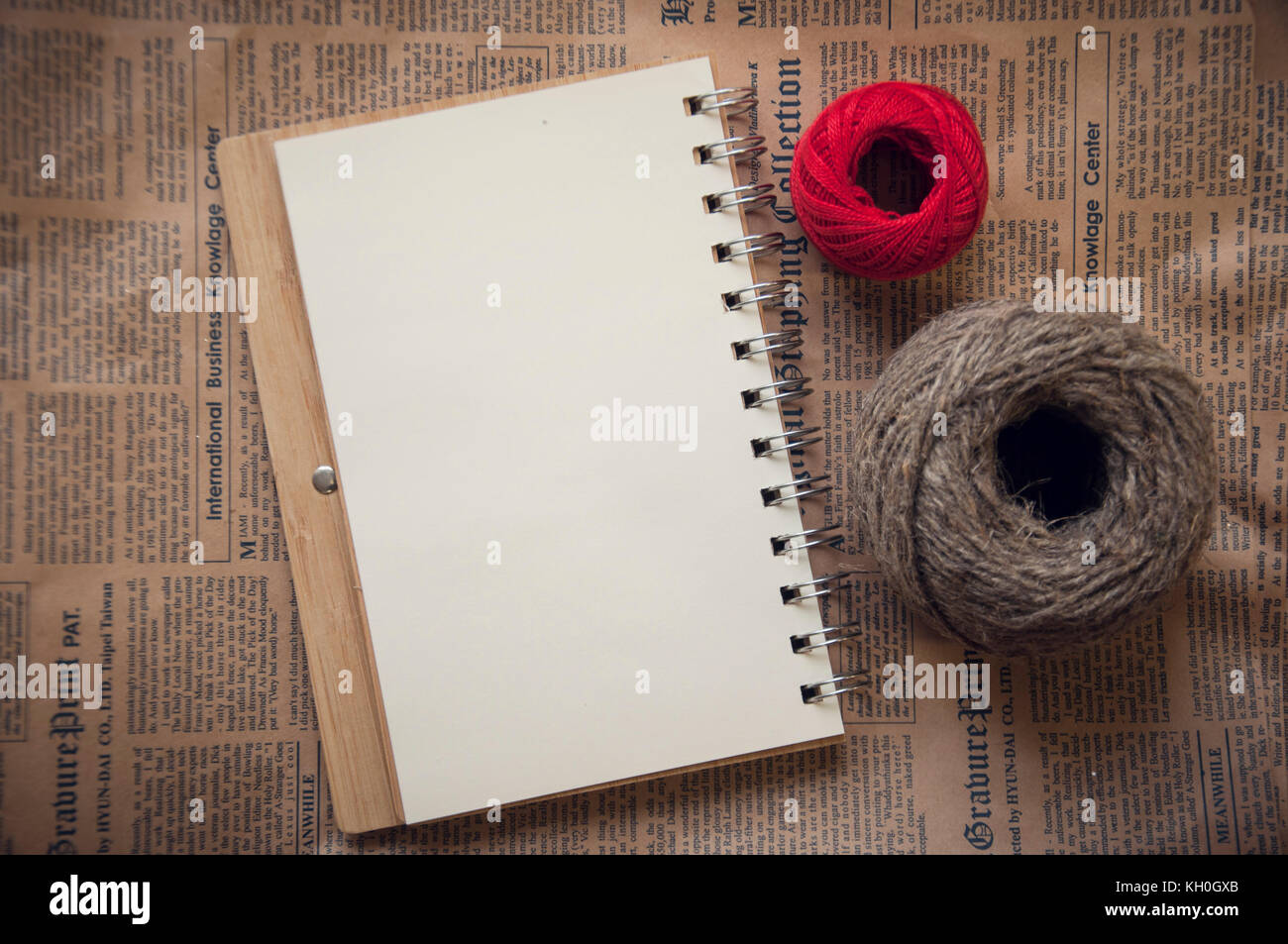 notepad and two coils of thread on brown old newspaper backgroun Stock ...