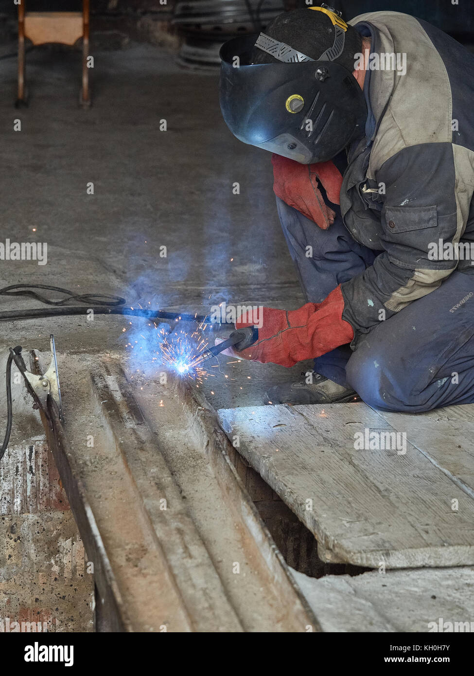 The photograph shows the work of a welder. A man working with a piece ...