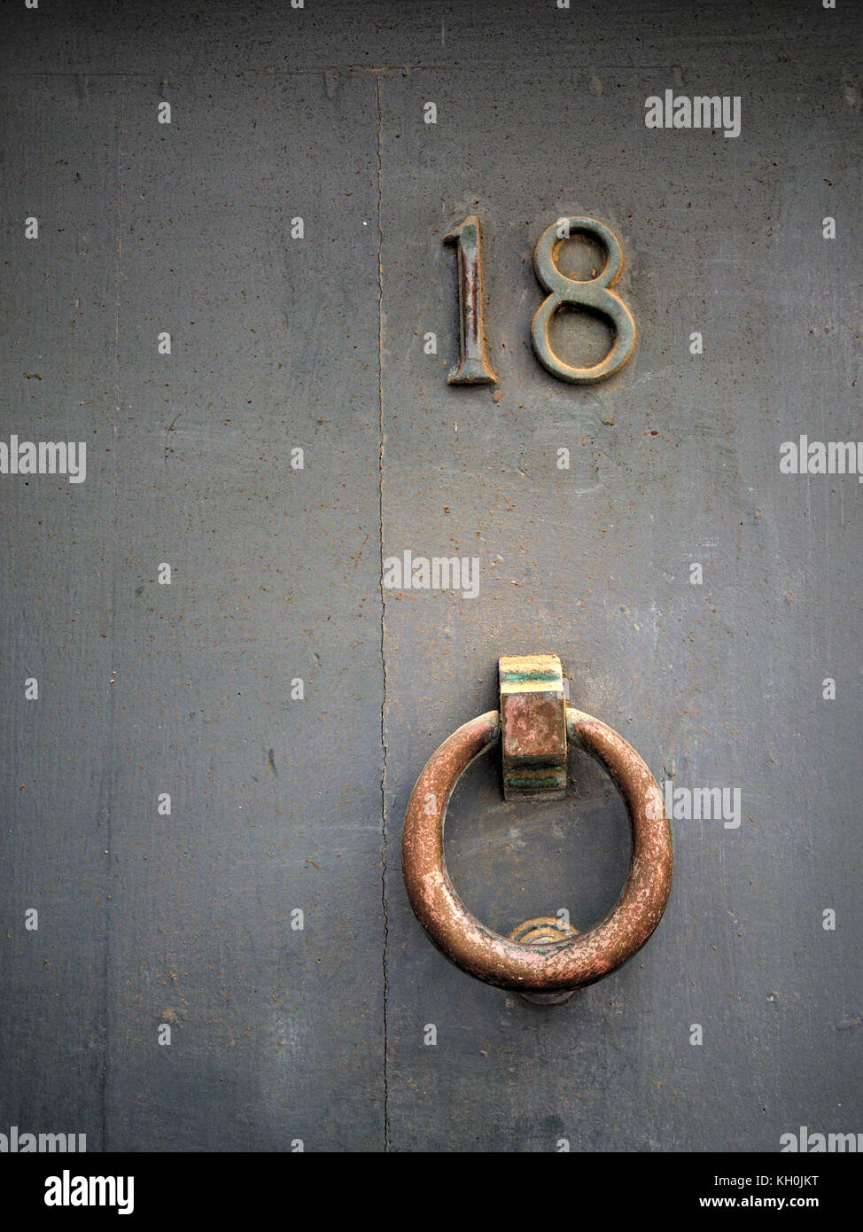 Number 18.Number 18 in metal on a greenish door with an old and rough ...