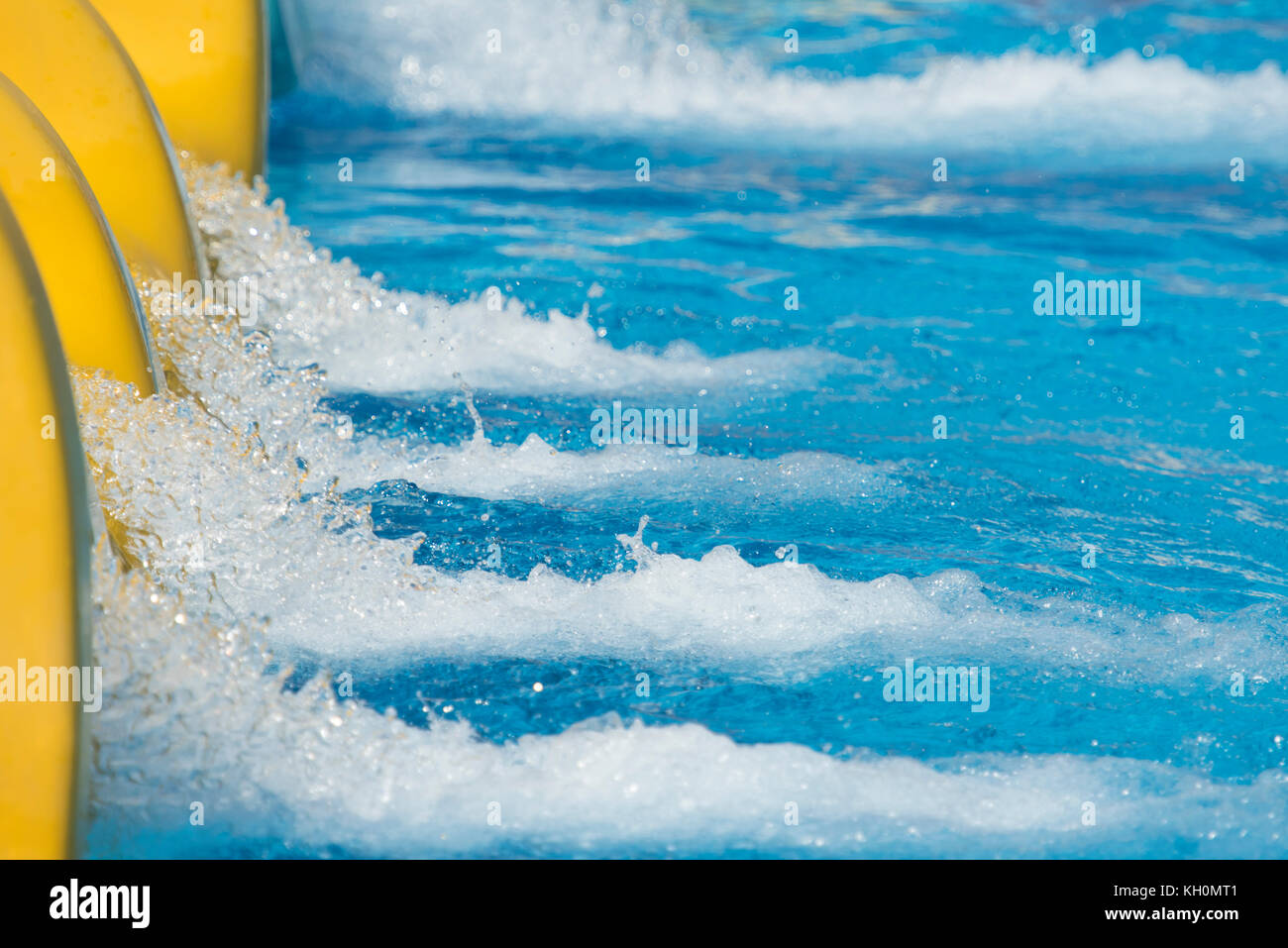 Water entering swimming pool from aqua park slide creating splash ...
