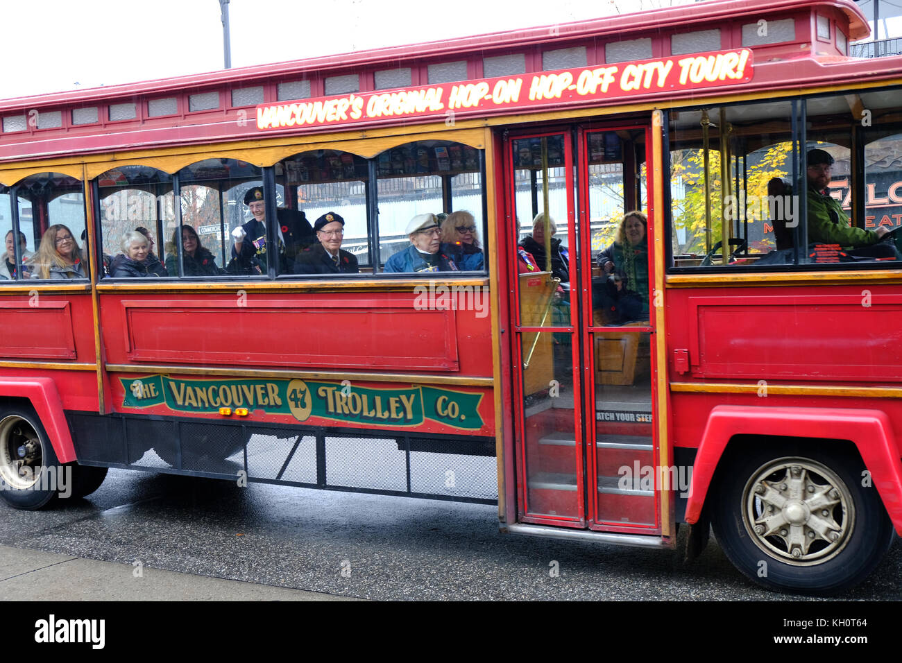 War veterans in red traditional bus looking out from Remembrance Day ...