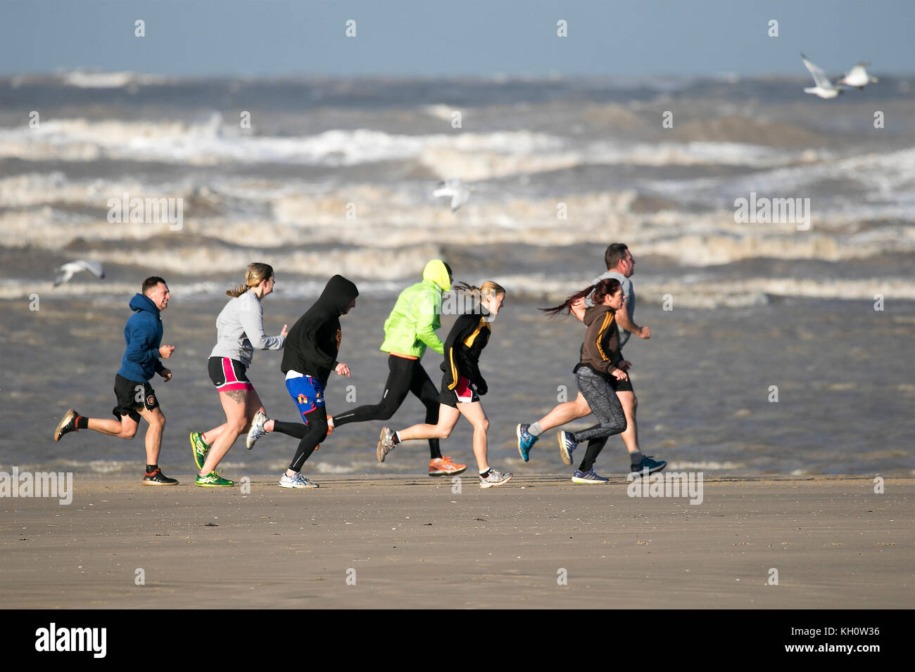 Summer bathing in the sea on a windy day at the coast in Southport, UK ...
