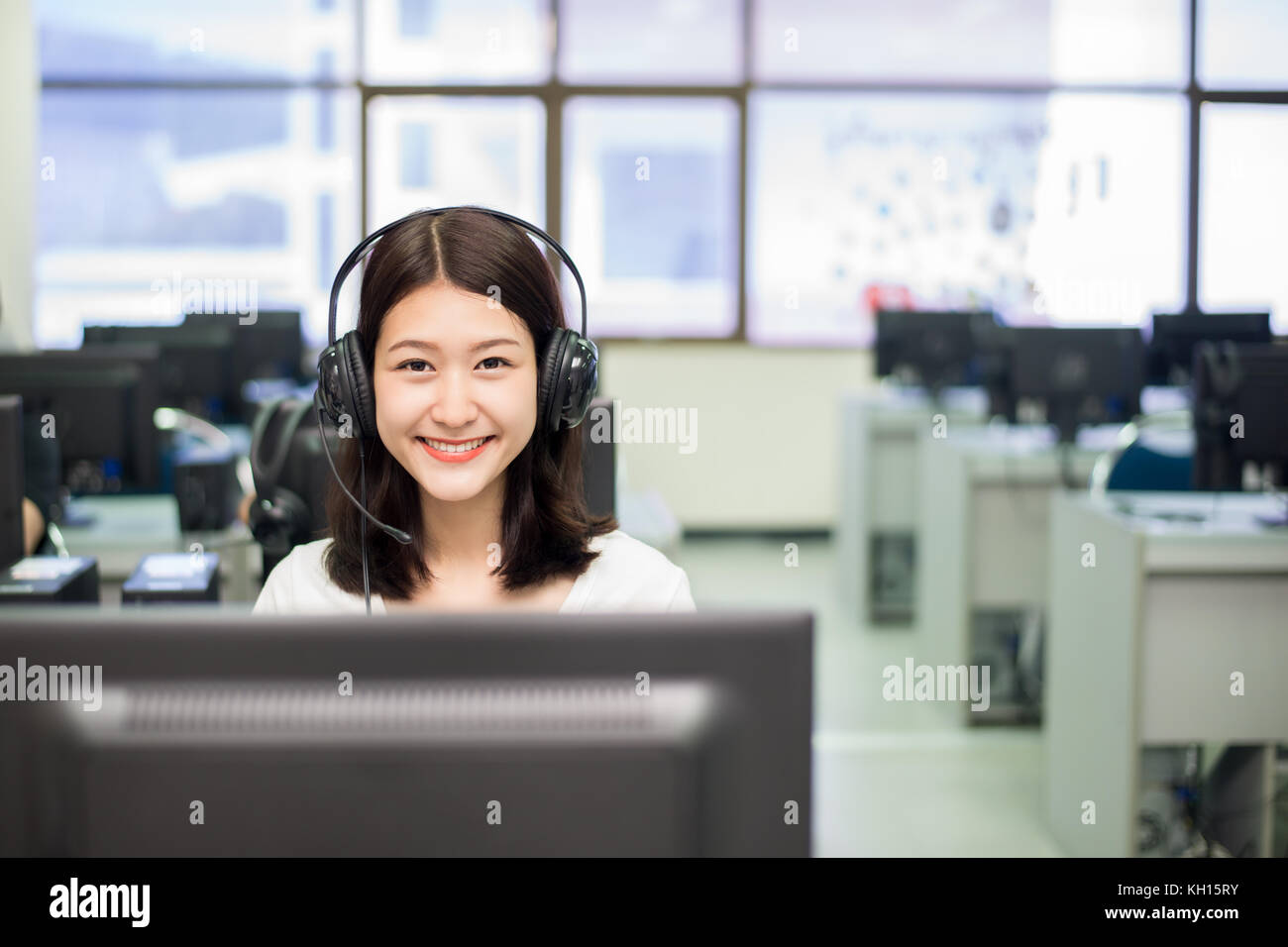Smiling Asian woman student posing with a computer while studying in IT ...