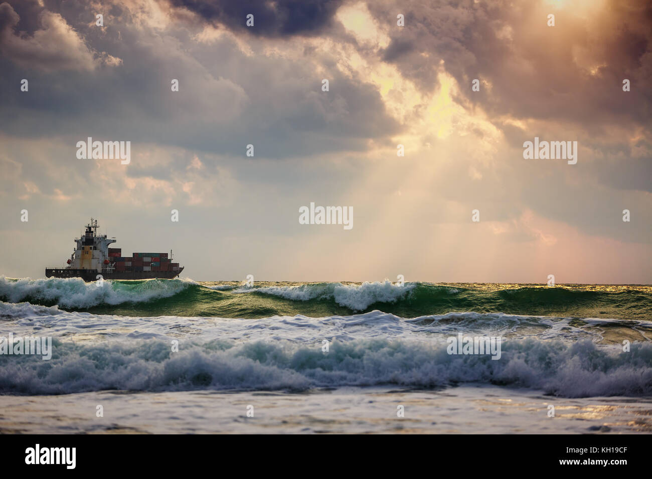Sun setting at the sea with sailing cargo ship, scenic view Stock Photo ...