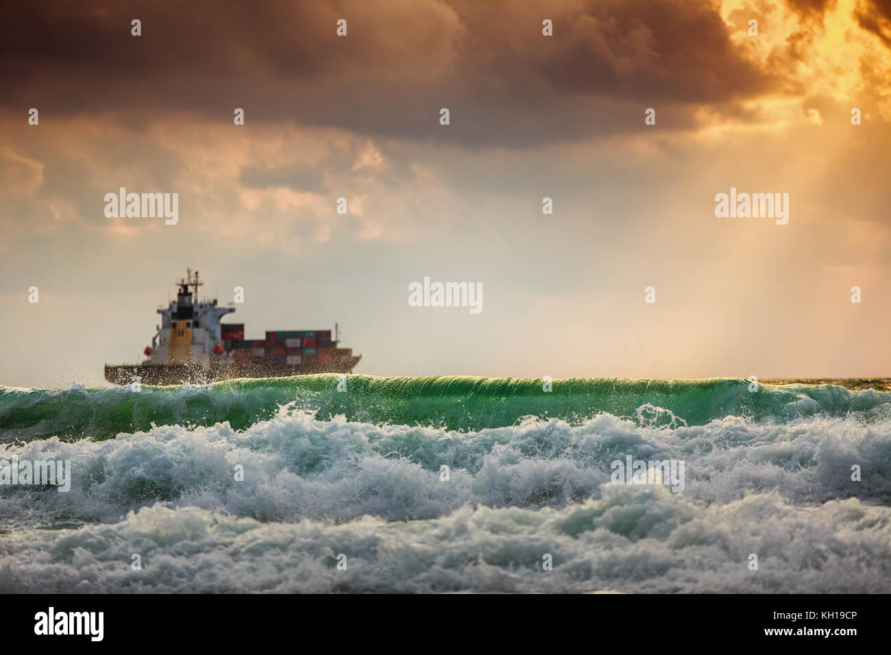 Sun setting at the sea with sailing cargo ship, scenic view Stock Photo ...