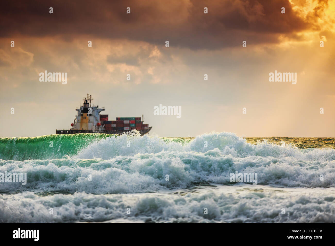 Sun setting at the sea with sailing cargo ship, scenic view Stock Photo ...