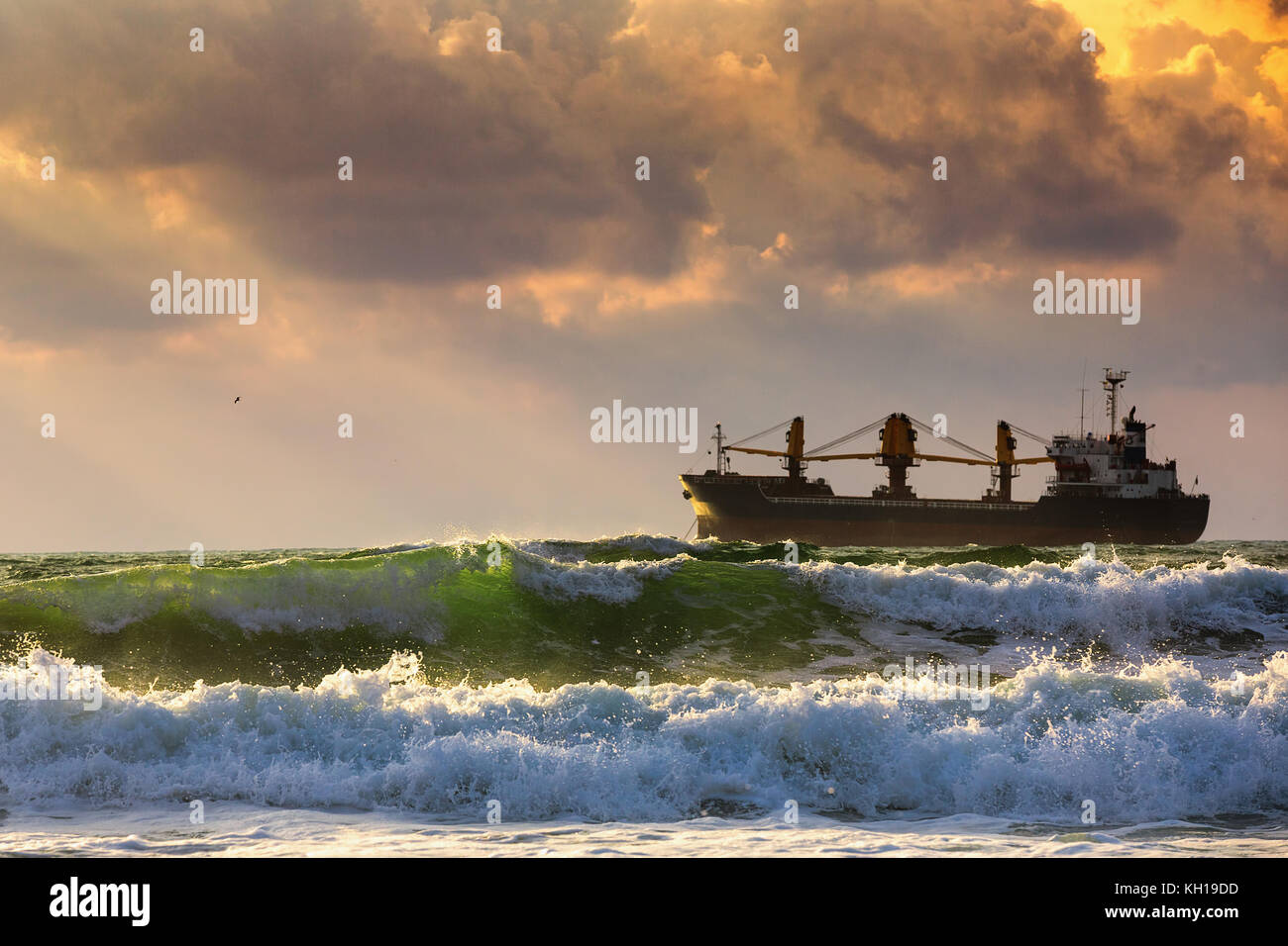 Sun setting at the sea with sailing cargo ship, scenic view Stock Photo ...