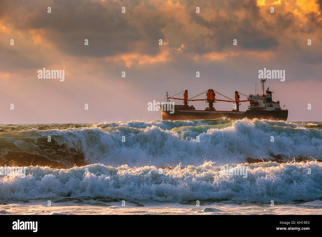 Sun setting at the sea with sailing cargo ship, scenic view Stock Photo ...