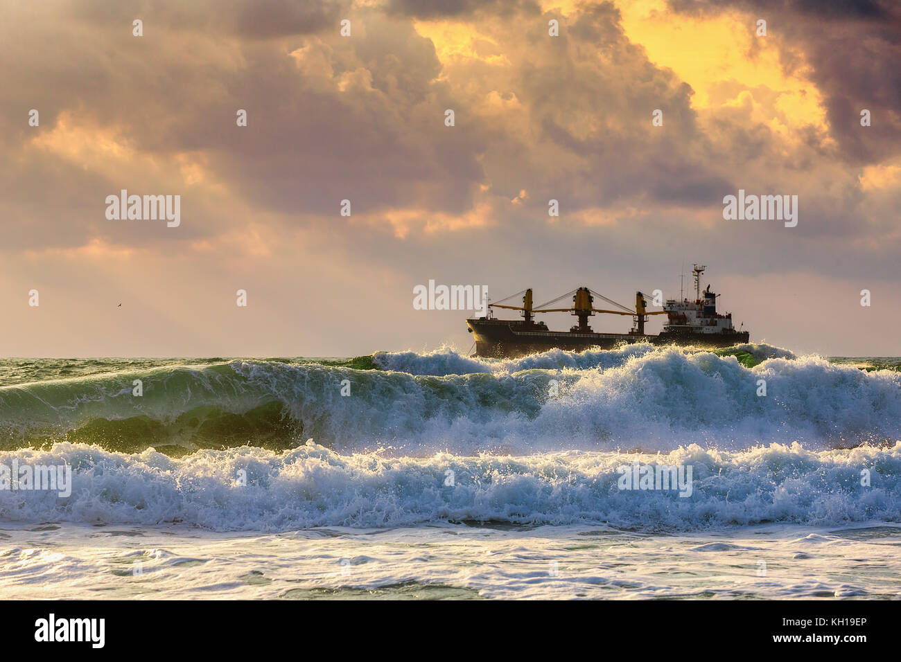 Sun setting at the sea with sailing cargo ship, scenic view Stock Photo ...