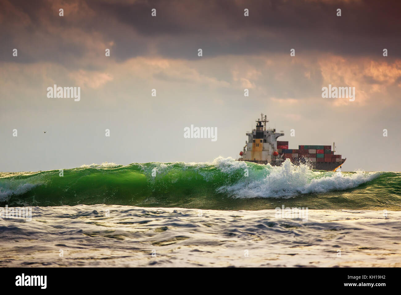 Sun setting at the sea with sailing cargo ship, scenic view Stock Photo ...