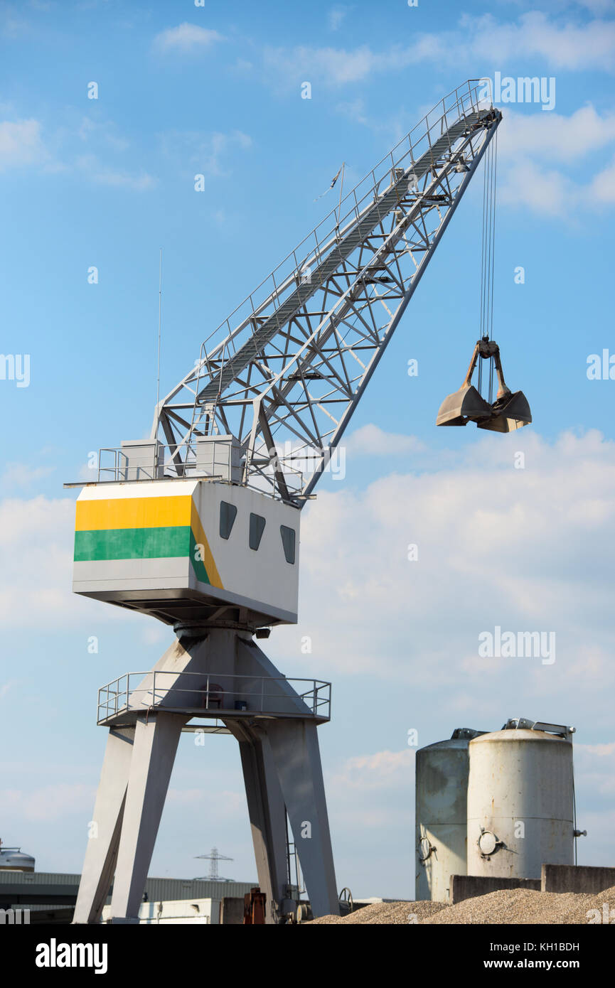 Open industrial crane hanging in blue sky Stock Photo - Alamy