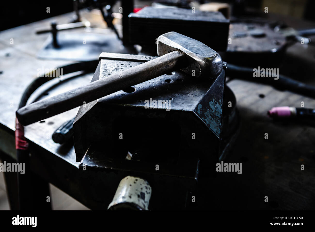 Hammer on anvil in smithery workshop.Professional blacksmith work table ...