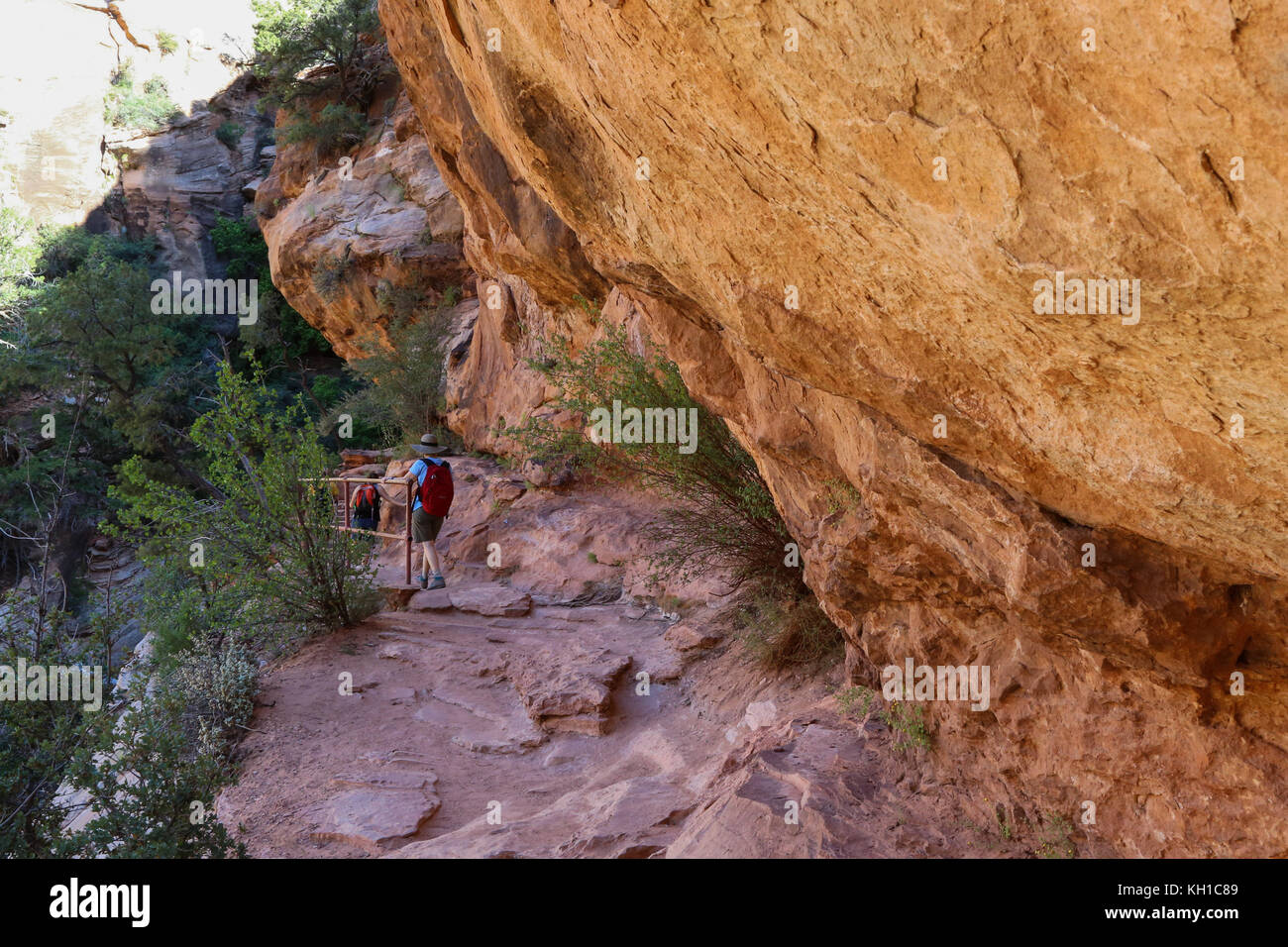 Hikers under a ledge on the Zion National Park Canyon Overlook Trail ...