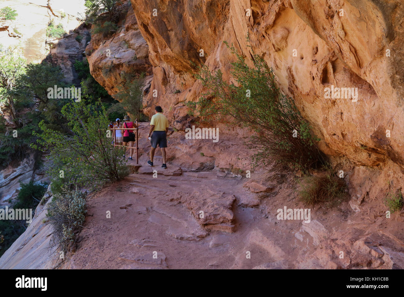 Hikers under a ledge on the Zion National Park Canyon Overlook Trail ...