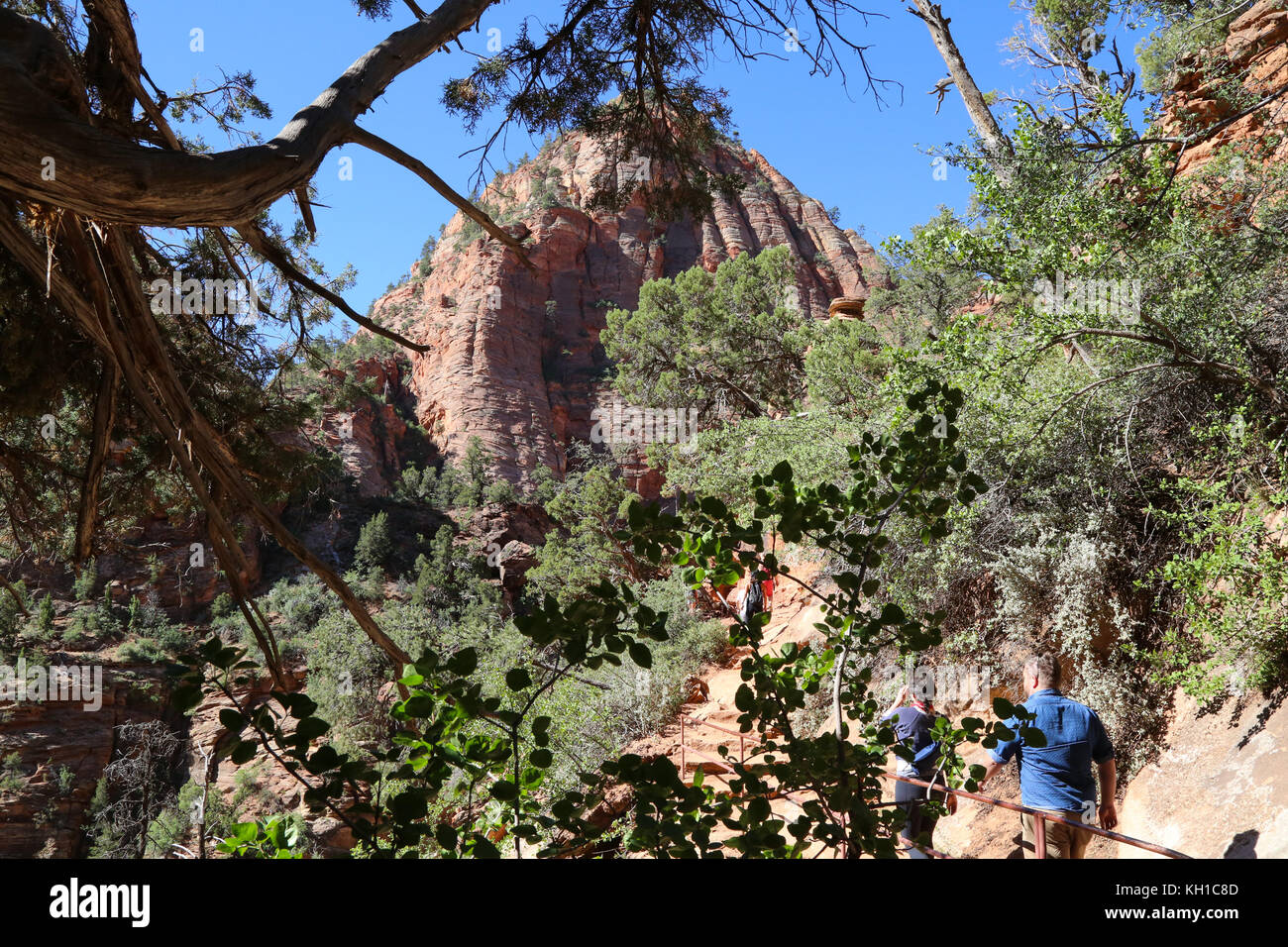 Hikers under a ledge on the Zion National Park Canyon Overlook Trail ...