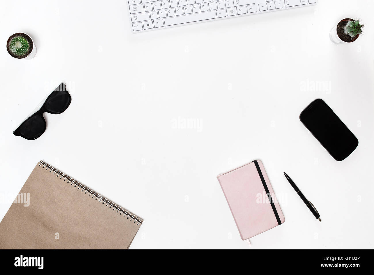 Feminine blogger's desk table with white keyboard,smatphone, cactus and ...