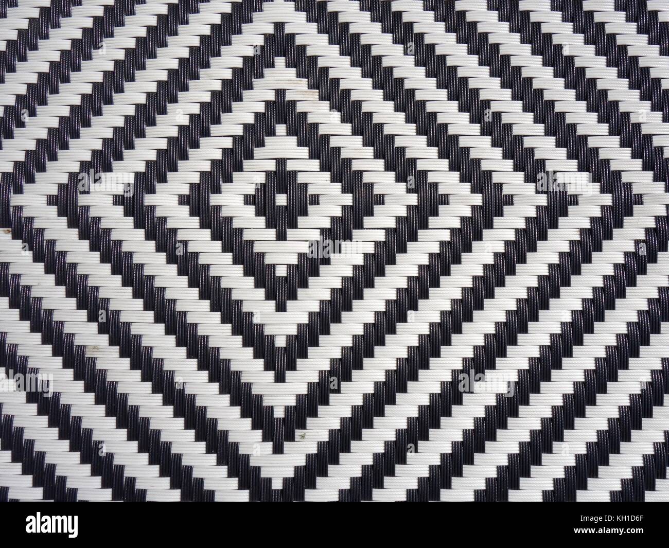 A black and white diamond pattern formed in woven plastic as a ...