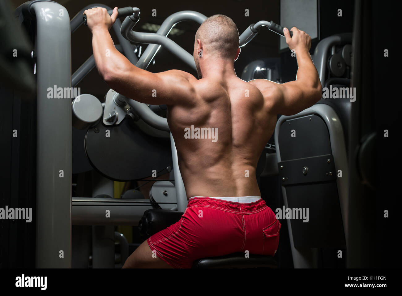 Handsome Bodybuilder Doing Heavy Weight Exercise For Back On Machine ...