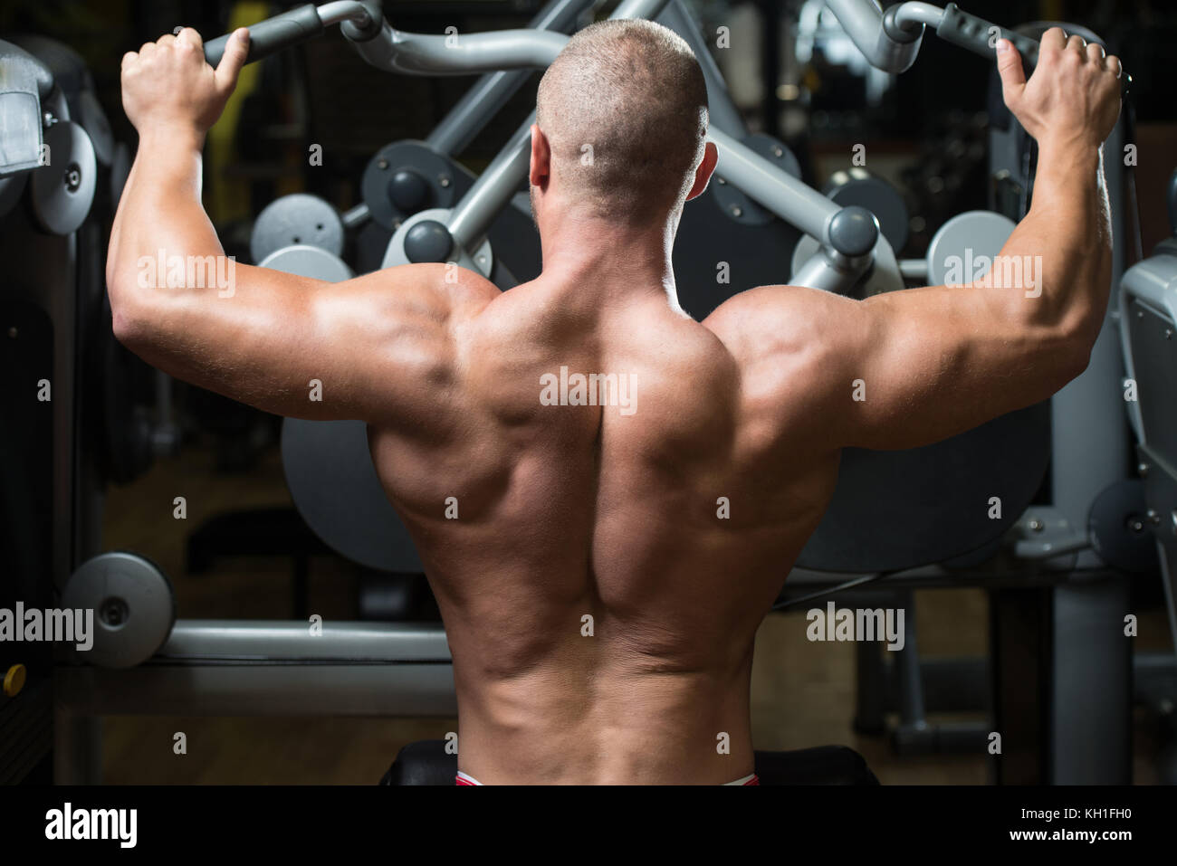 Handsome Bodybuilder Doing Heavy Weight Exercise For Back On Machine ...