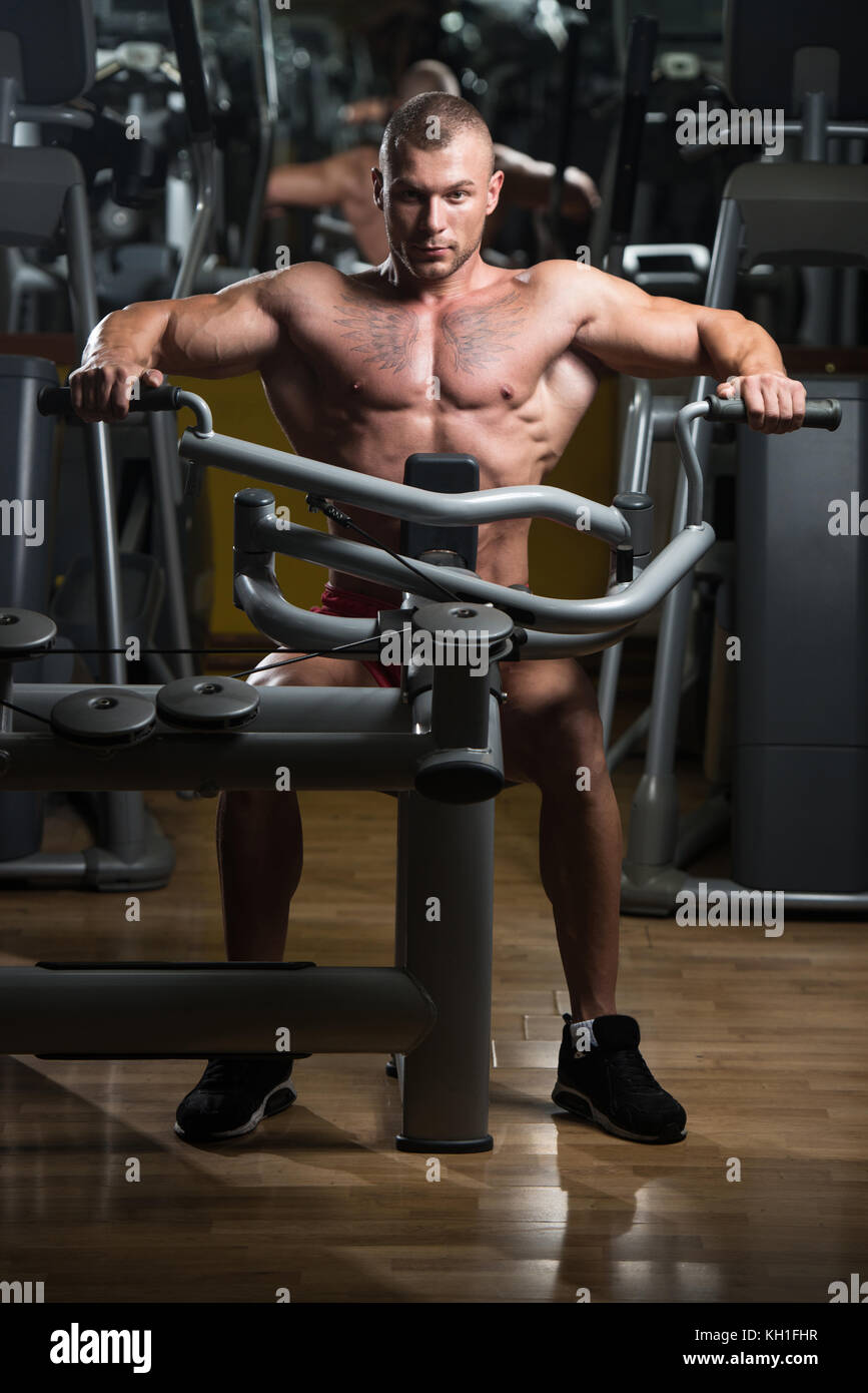 Handsome Bodybuilder Doing Heavy Weight Exercise For Back On Machine ...