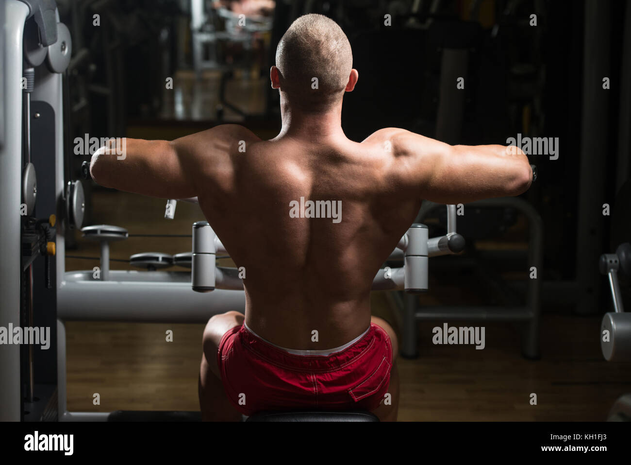Handsome Bodybuilder Doing Heavy Weight Exercise For Back On Machine ...