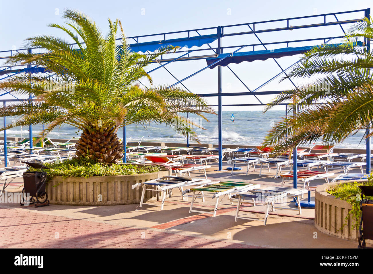 Empty beach with sun loungers and surfboard in summer day Stock Photo ...