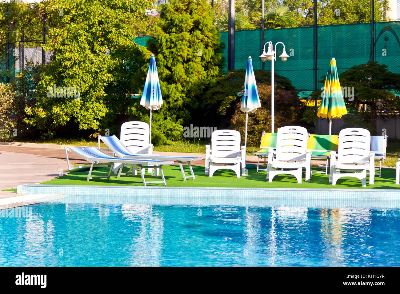 Empty swimming pool with sun loungers in summer day Stock Photo - Alamy