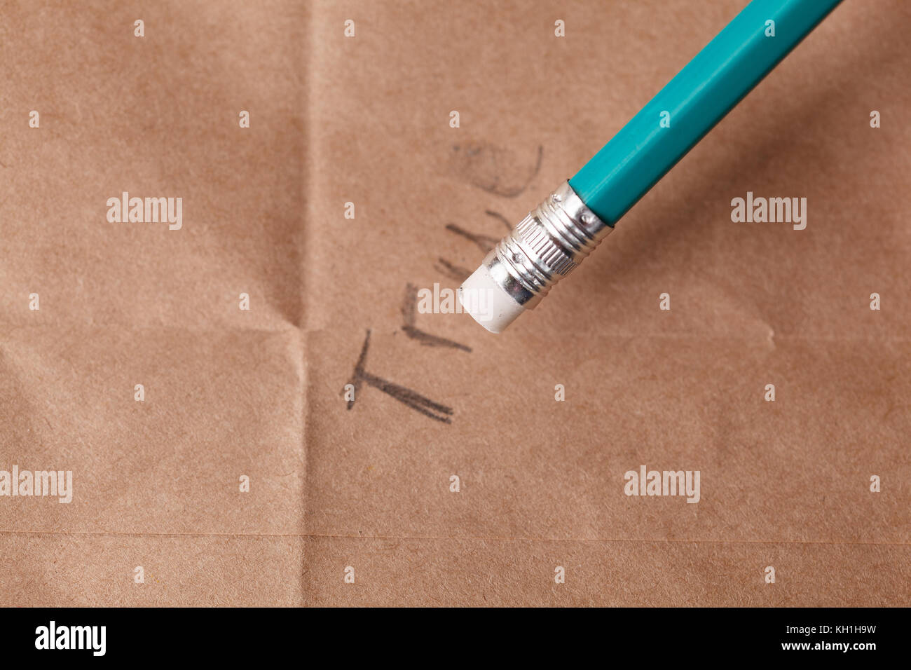 Pencil erasing a word True. True hiding concept Stock Photo - Alamy