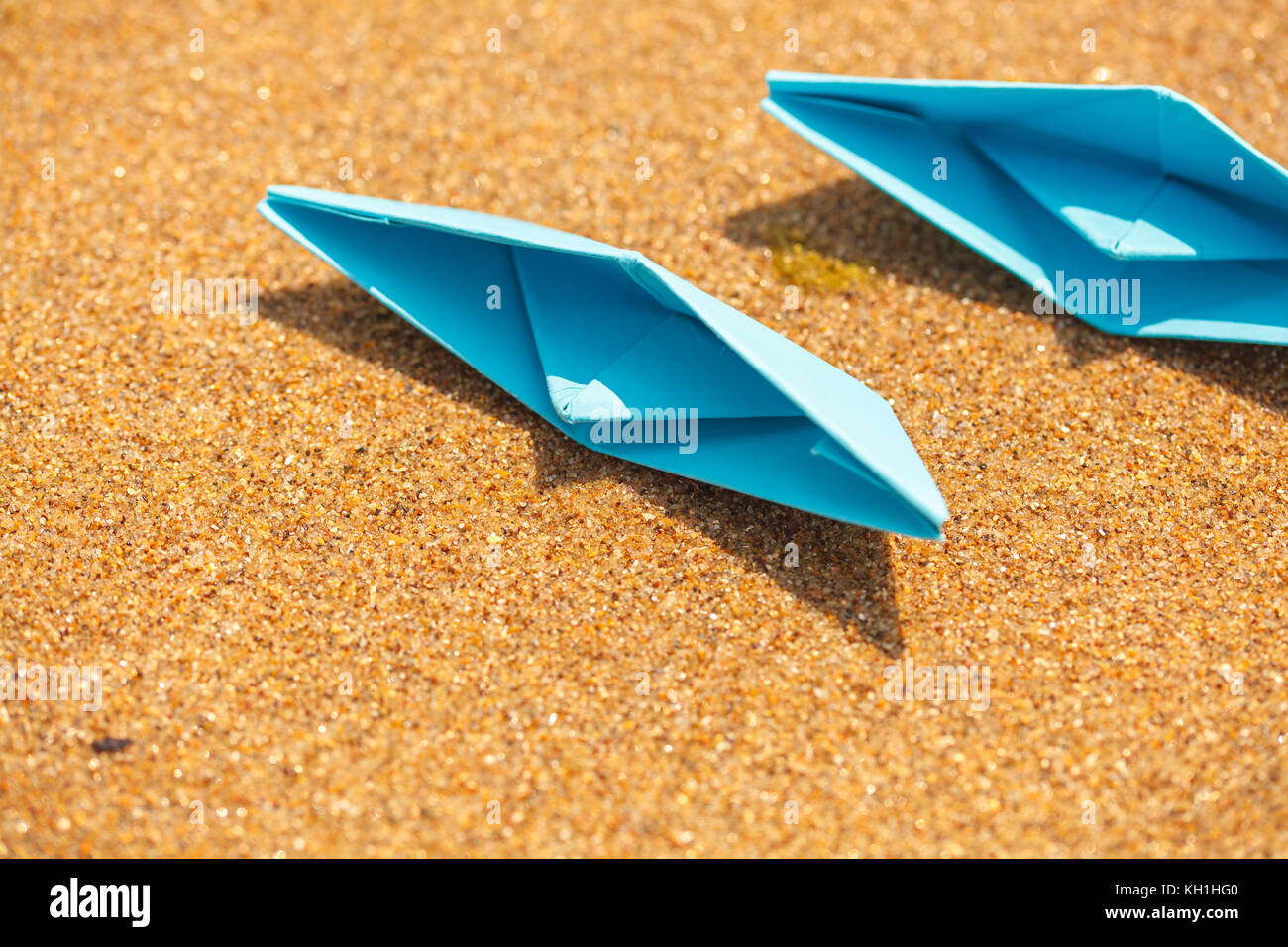 Blue paper boats on beach sand outdoors. Travel concept Stock Photo - Alamy