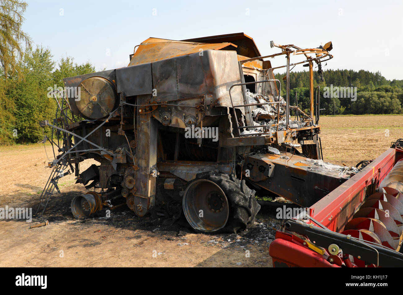 Burnt out combine harvester in field Stock Photo - Alamy