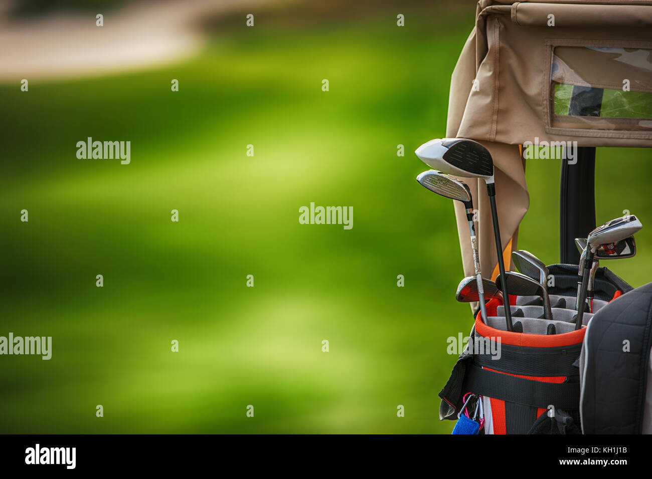 Golf clubs drivers over green field background Stock Photo - Alamy