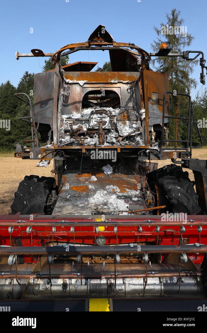 Burnt out combine harvester in field - front view Stock Photo - Alamy