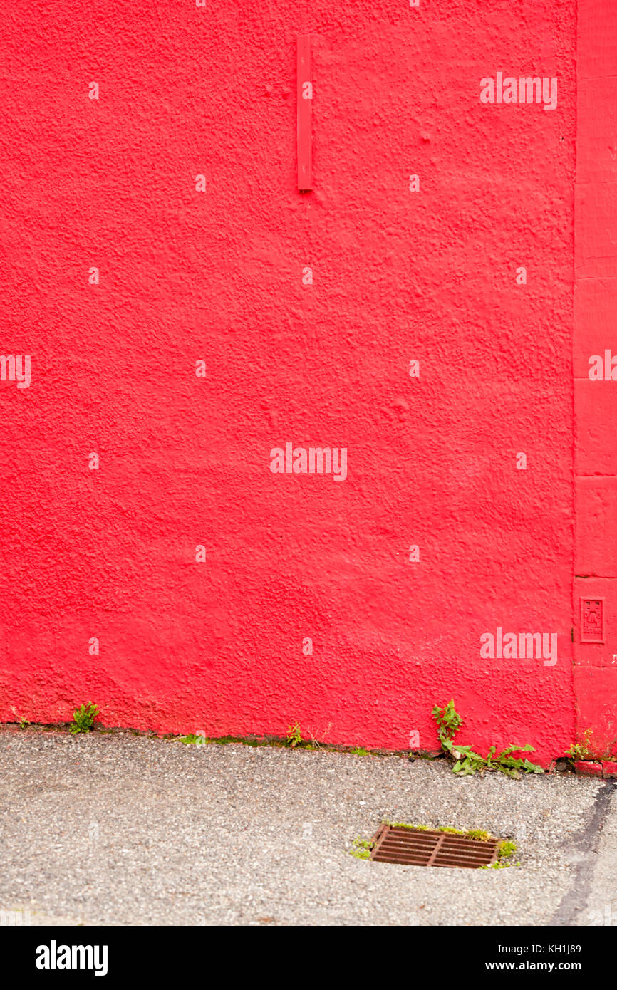 Wall painted red on the street with only one sidewalk in front Stock ...