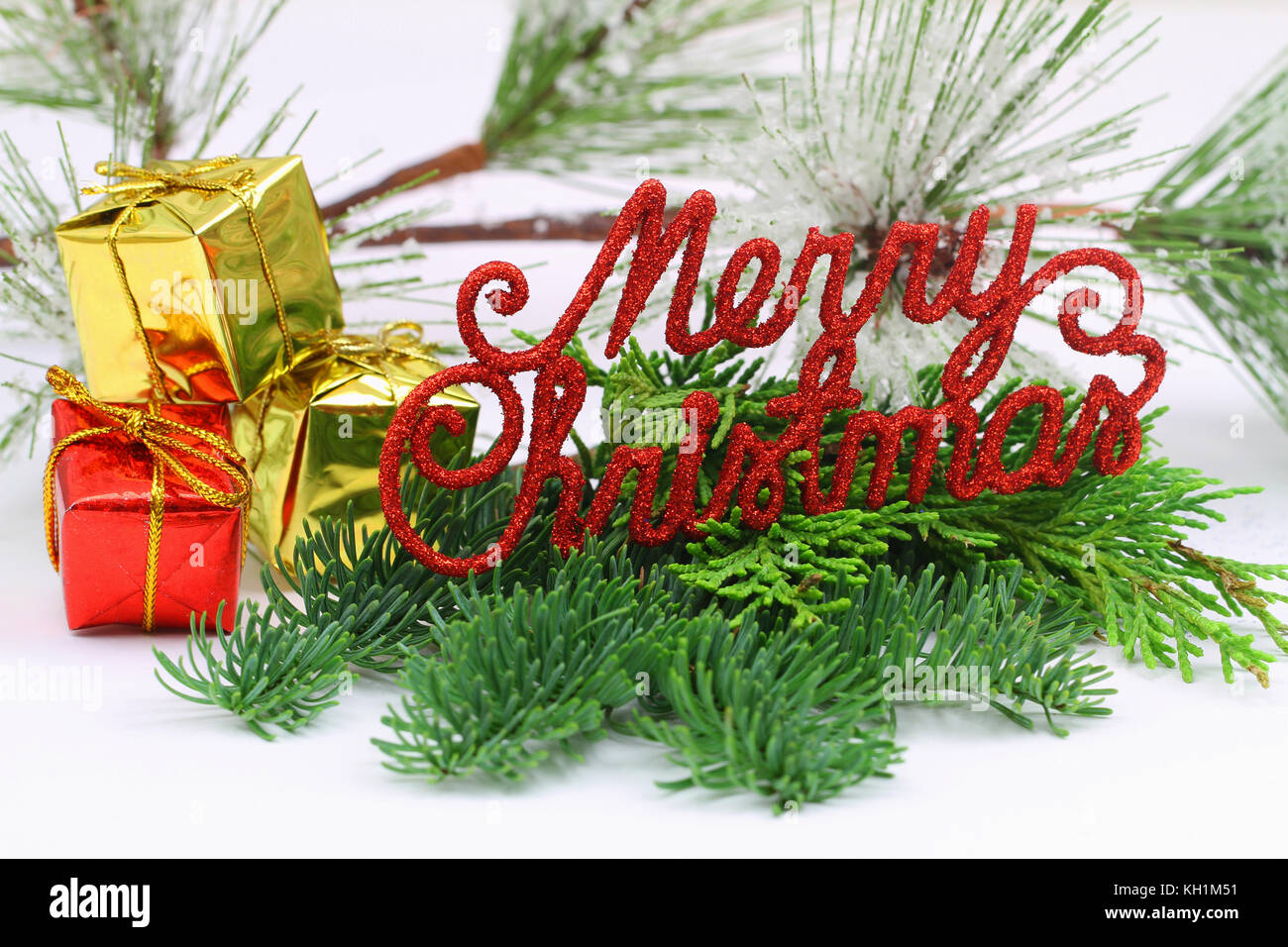 Merry Christmas written with letters covered in red glitter on pine and ...