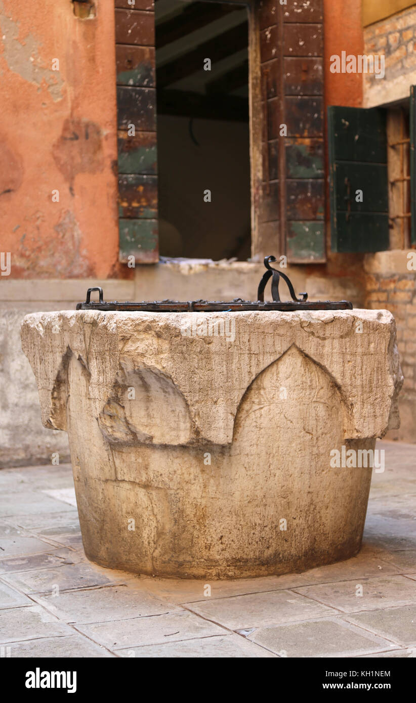 very ancient stone well in a square of a European city Stock Photo - Alamy