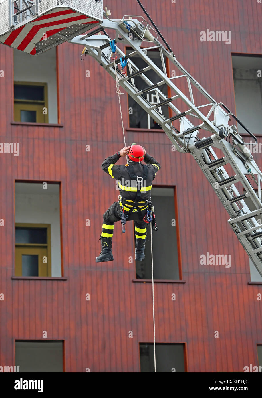 brave rescuer with red helmet descends from the platform during a ...