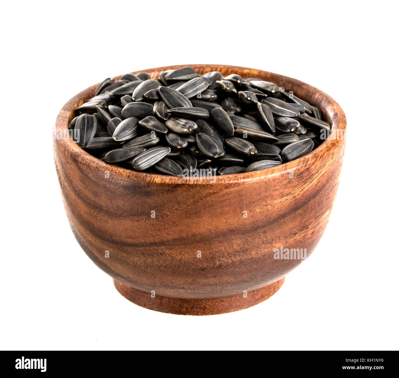 sunflower seeds in a wooden bowl, isolated on white background with ...