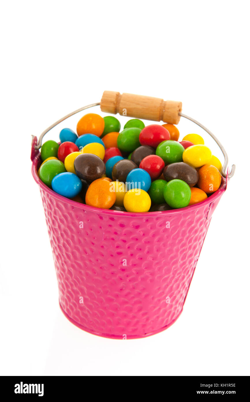 colorful sugar sweets in pink bucket isolated over white background ...