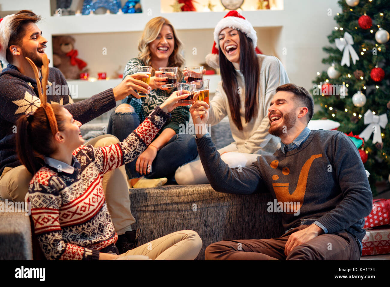 Group of friends celebrating Christmas at home, they are having fun ...