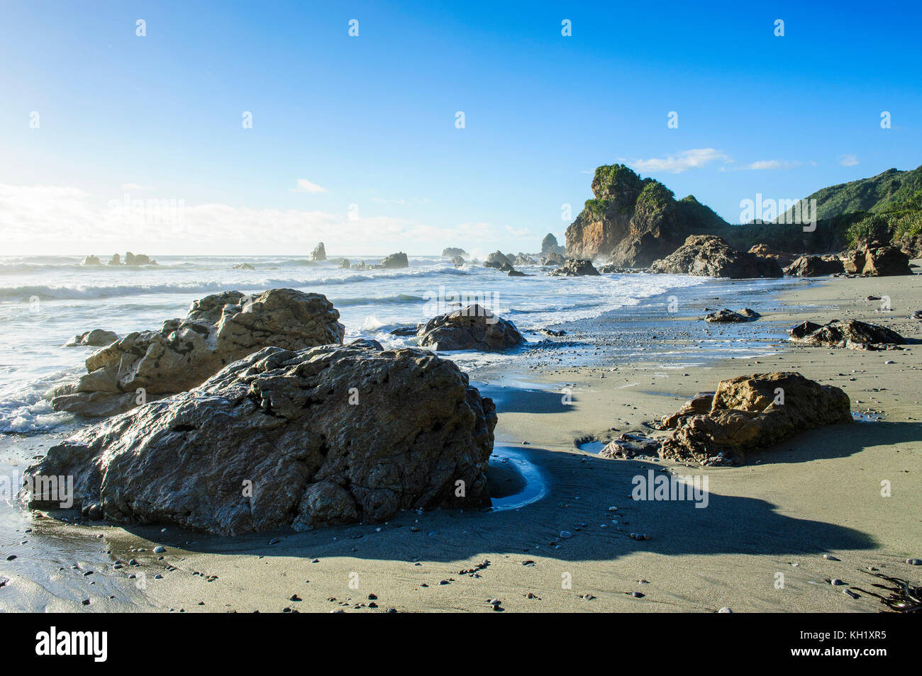 Huge rocks on a sandy beach on the wild west coast of South island ...