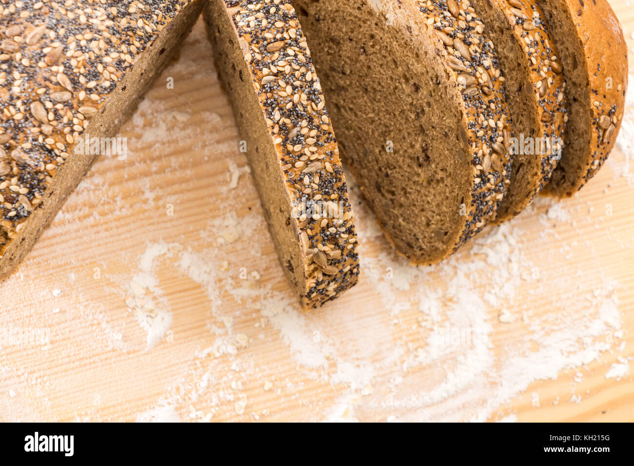 Whole wheat sliced bread closeup, on wooden surface with flour Stock ...