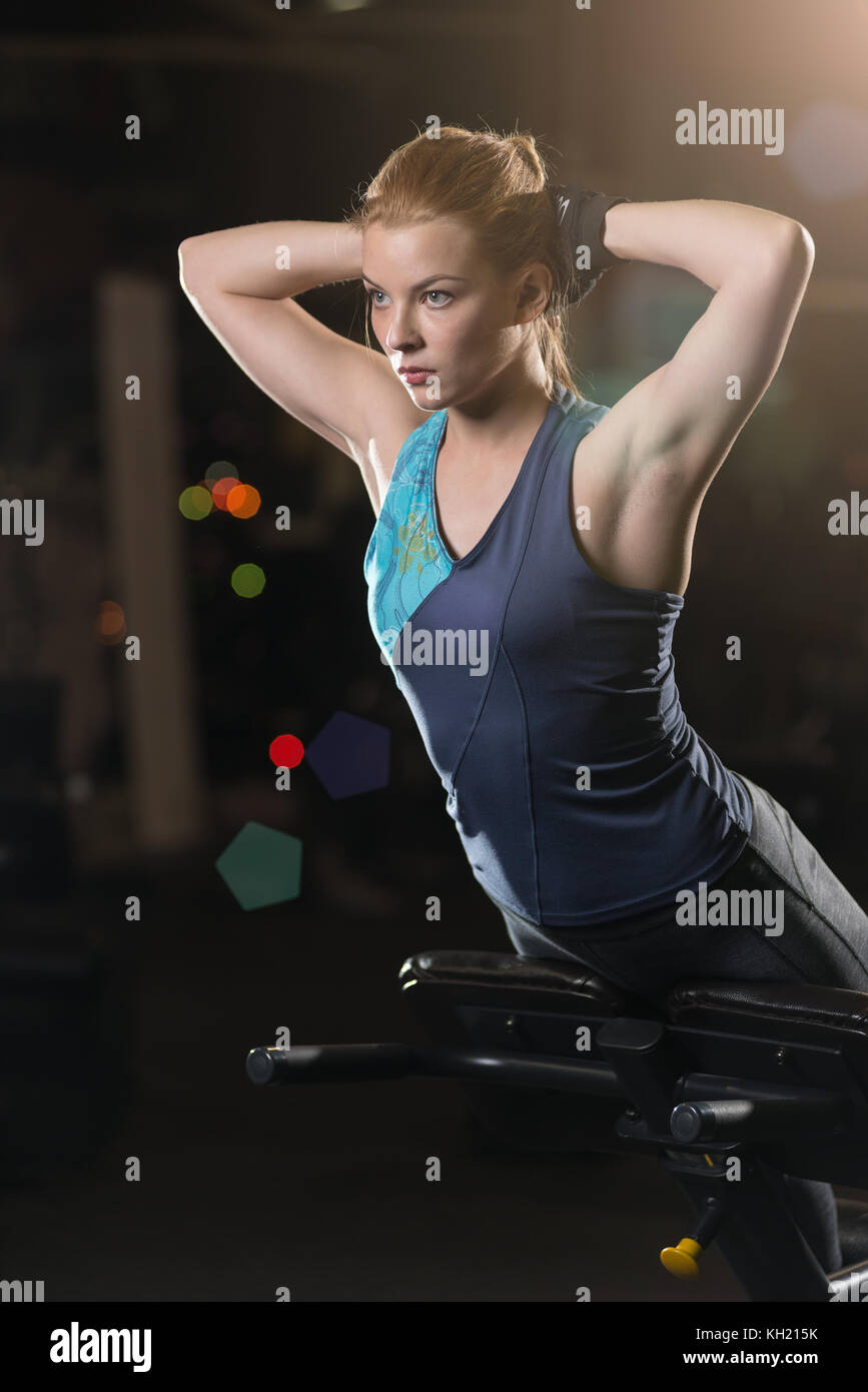 Woman doing strength exercises for abdominal muscles at indoor sport ...