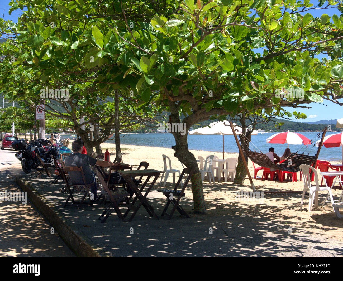 Relaxing at in a shady spot at a beach side bar Stock Photo - Alamy