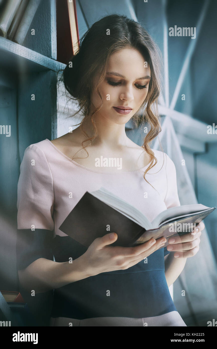 Young girl reads carefully book Stock Photo - Alamy